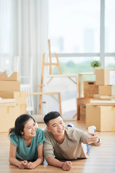 Asian Young Couple Carrying Big Cardboard Box Together While Moving
