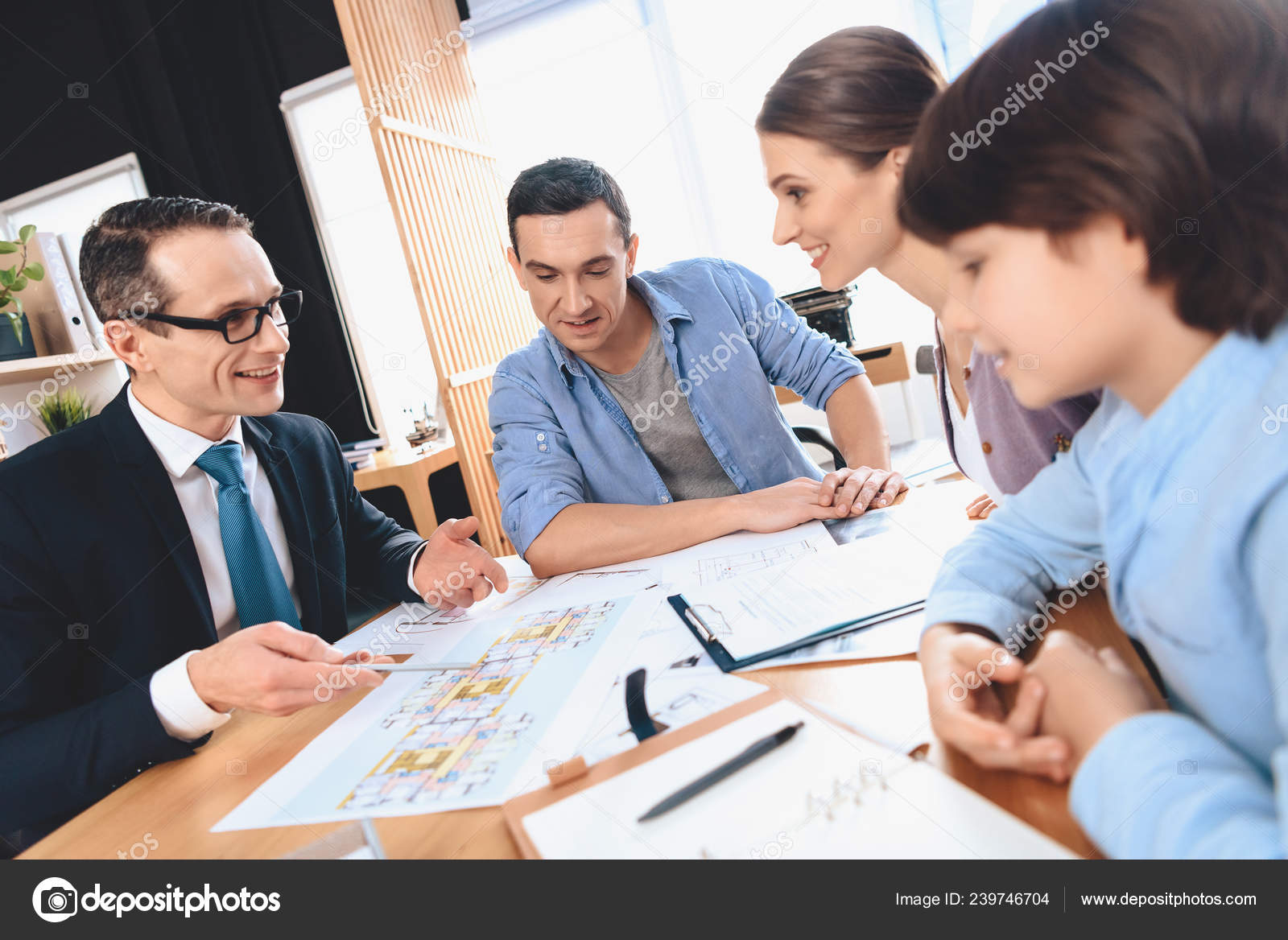 Realtor sitting at desk in office. Realtor is discussing apartment ...