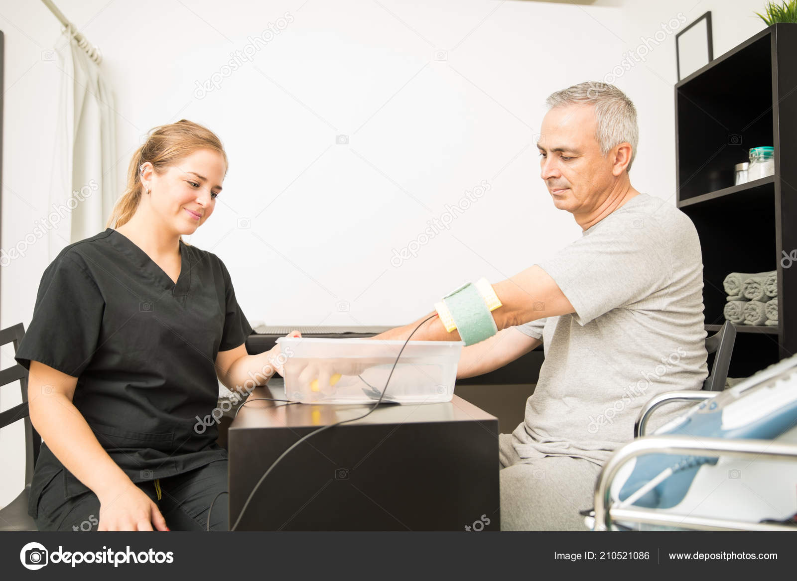 Young Physiotherapist Giving Electrotherapy Mature Patient Table ...