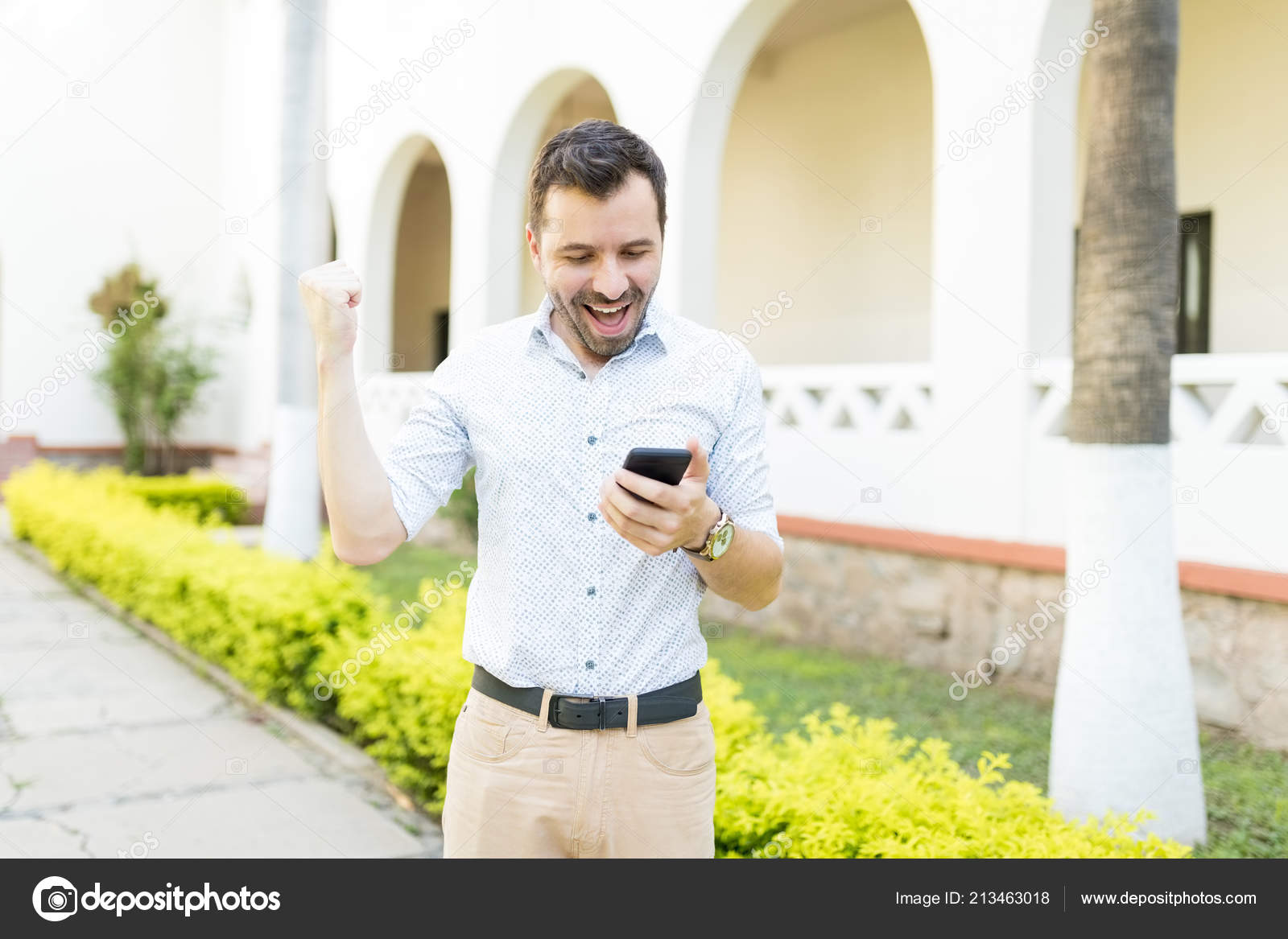 Male Looking Cellphone Victorious Expression While Standing Garden ...