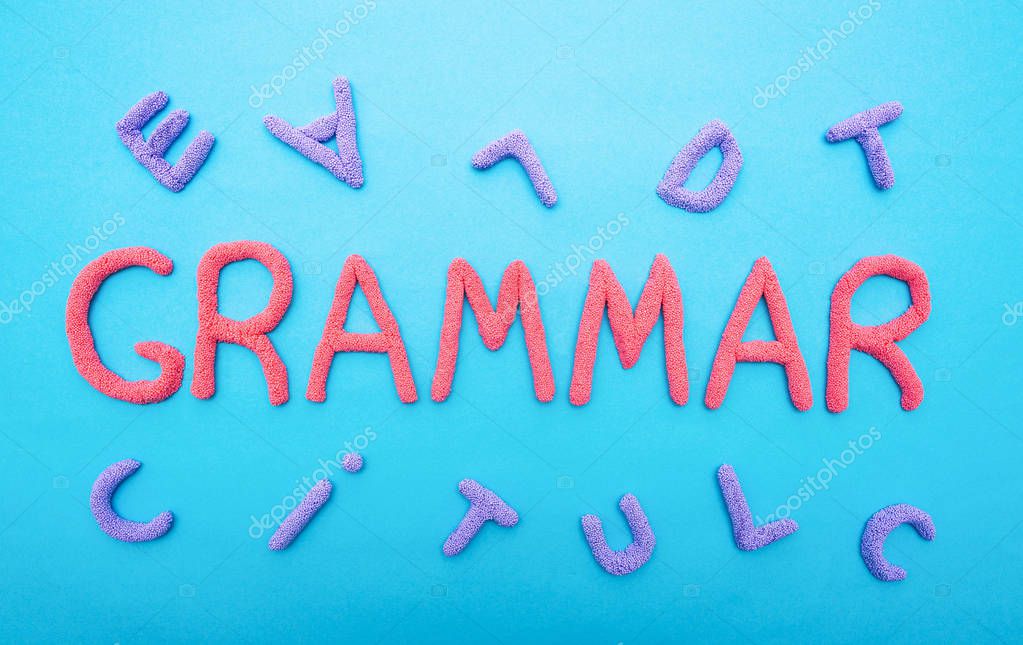 La palabra gramática sobre un fondo azul y letras dispersas de una ...