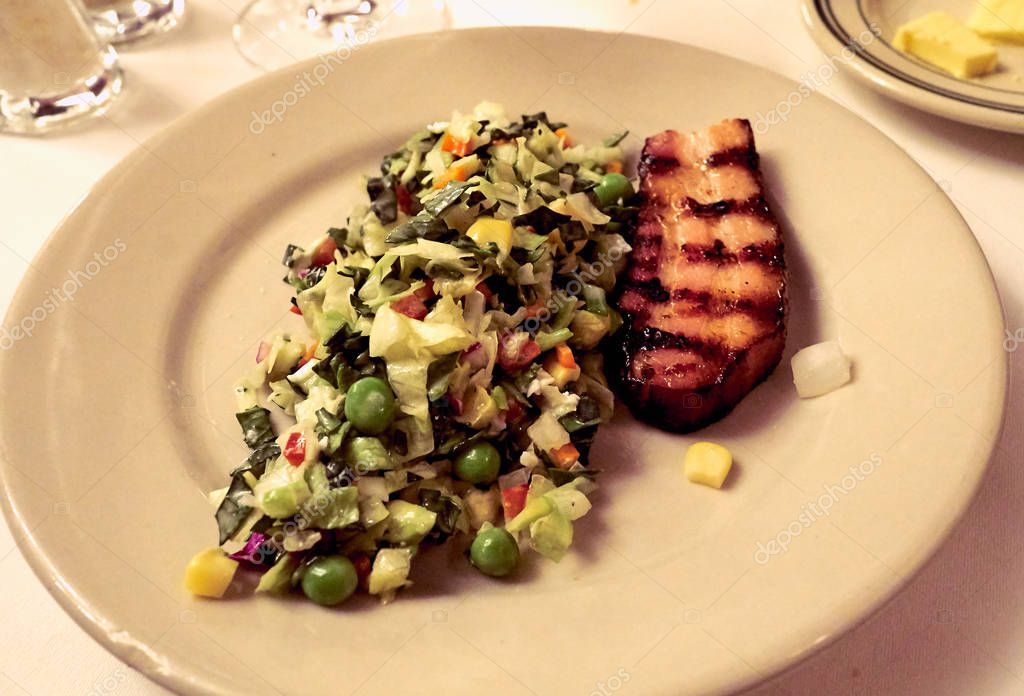 Tocino a la parrilla y ensalada con lechuga picada, guisantes verdes ...