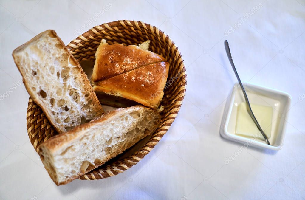 Una vista del pan servido en una canasta y mantequilla con un cuchillo ...