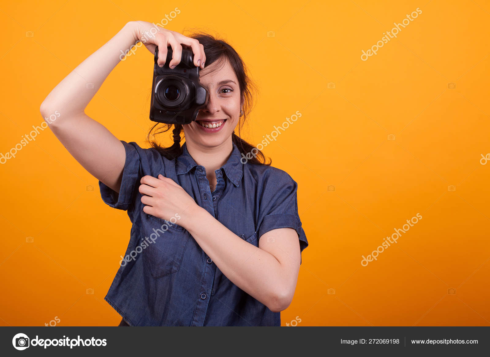 Woman photographer is taking images with dslr camera in studio over ...