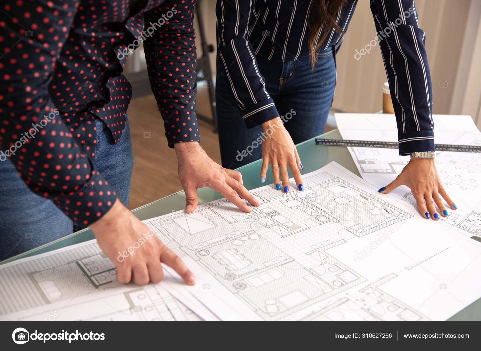 Close up with the hands of two architects pointing to a project plan ...