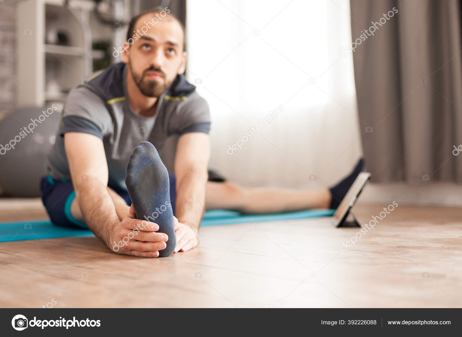 Active man on yoga mat at home Stock Photo by ©DragosCondreaW 392226088