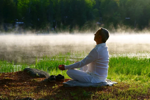 Meditation by the river. Early morning. Sunrise with some mist on the ...