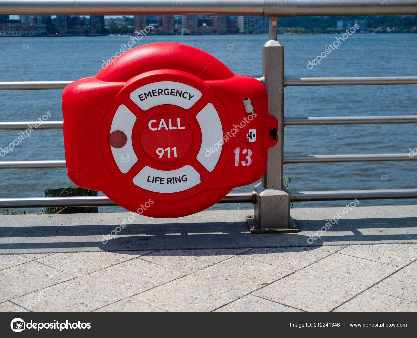 Red emergency life ring hanging on railing next to river — Stock Photo ...