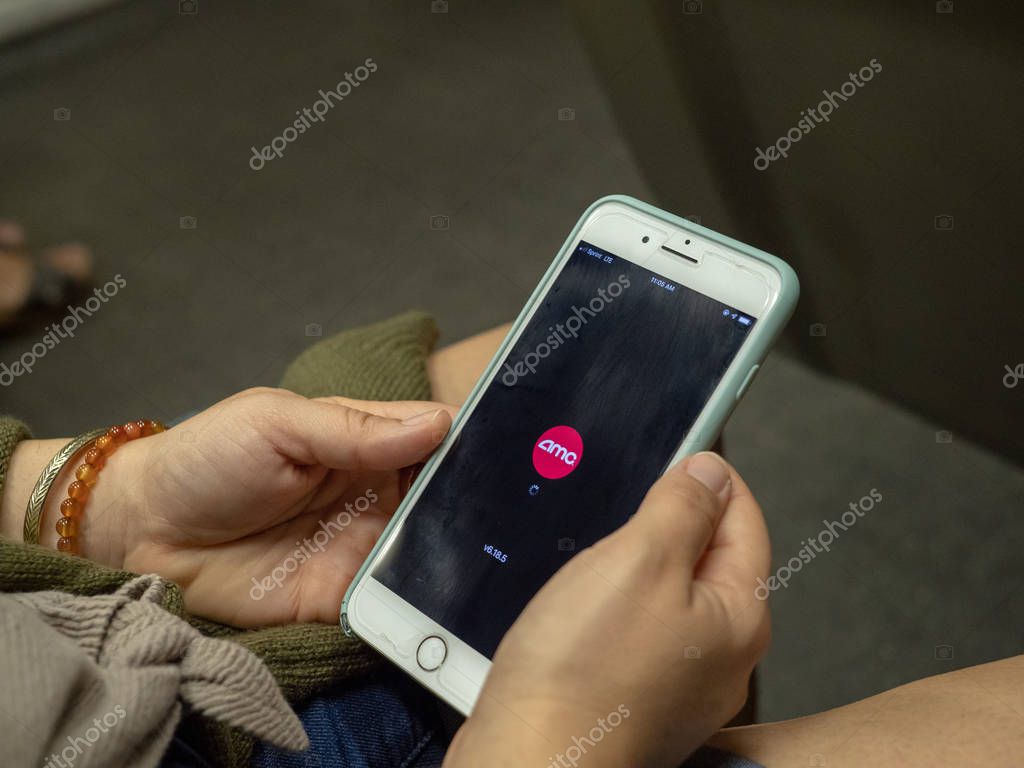 Mujer utiliza la aplicaci n m vil de cine AMC en el iPhone mientras viaja en tren subterr neo 2024