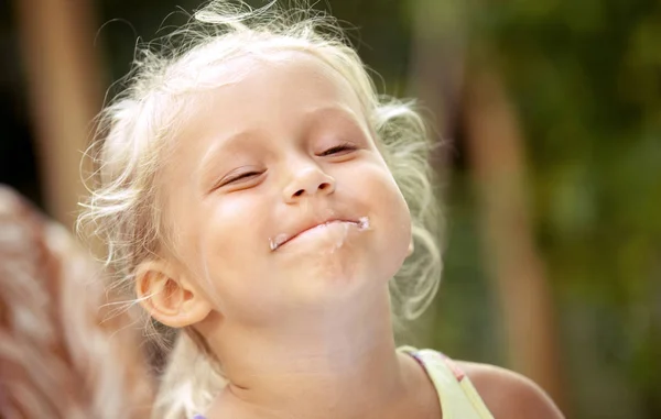 Cute little girl child with traces of ice cream on her face on a ... Cute little girl child with traces of ice cream on her face on a ...