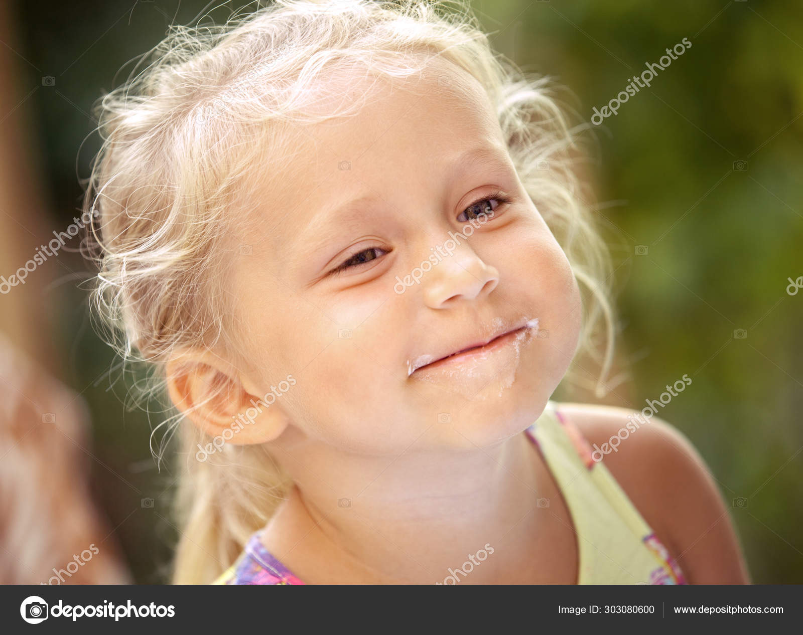 Cute little girl child with traces of ice cream on her face on a ... Cute little girl child with traces of ice cream on her face on a ...