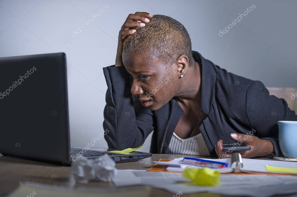 joven mujer de negocios afroamericana desesperada y estresada que trabaja en el escritorio de la ...