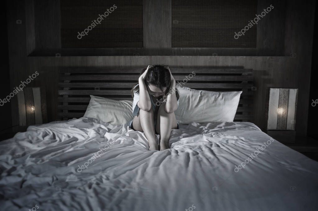 mujer joven desesperada y deprimida llorando en la cama por la noche ...