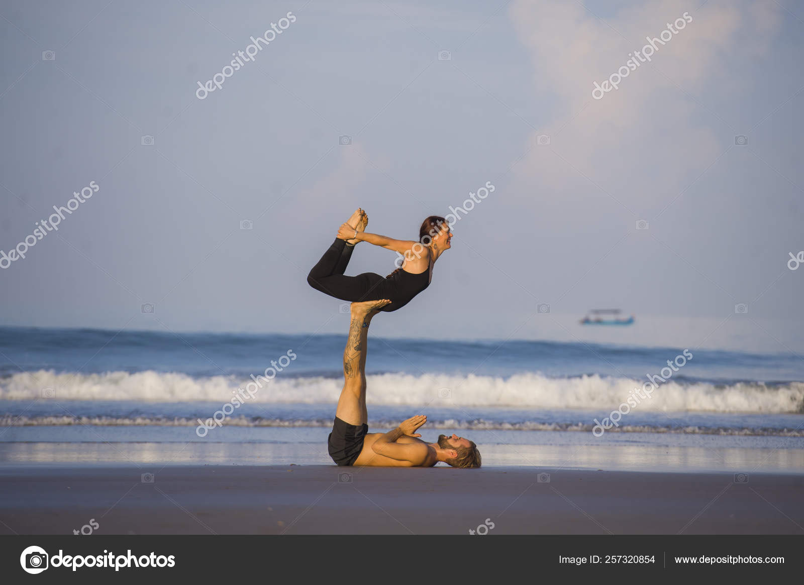 Young attractive and beautiful acrobat couple practicing acroyoga ...