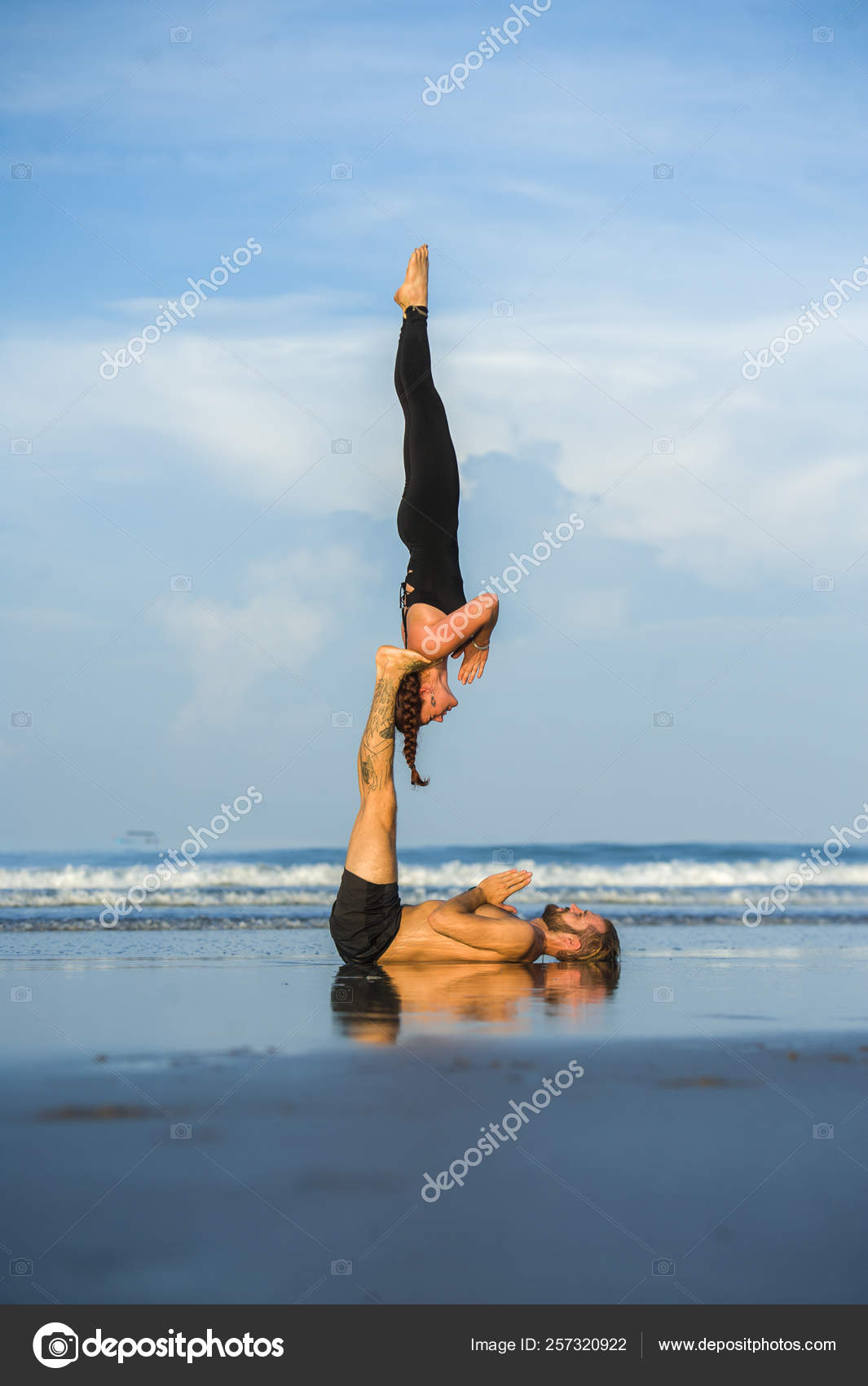 Young attractive and beautiful acrobat couple practicing acroyoga ...