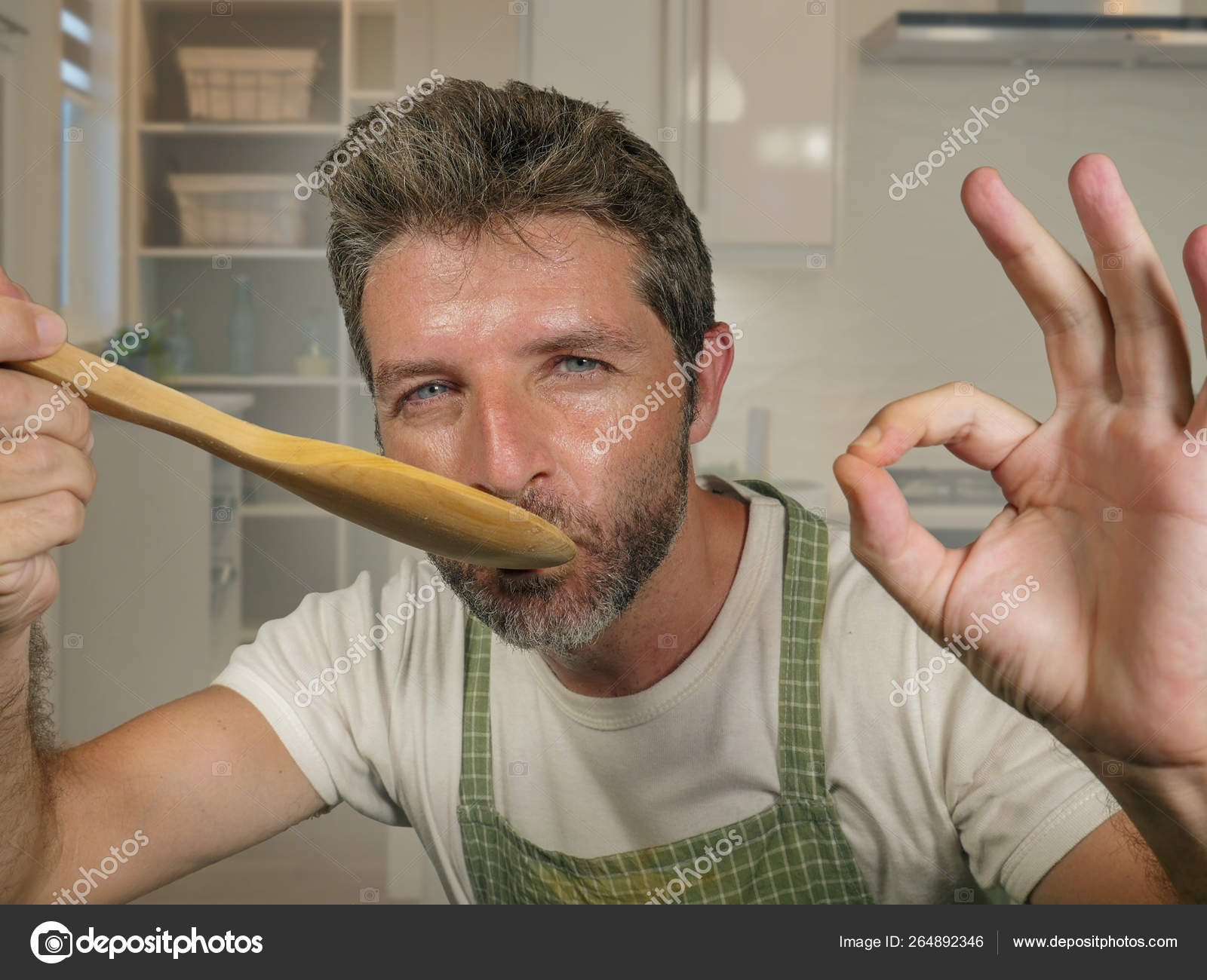 Happy and attractive home cook man in apron smiling cheerful and ...