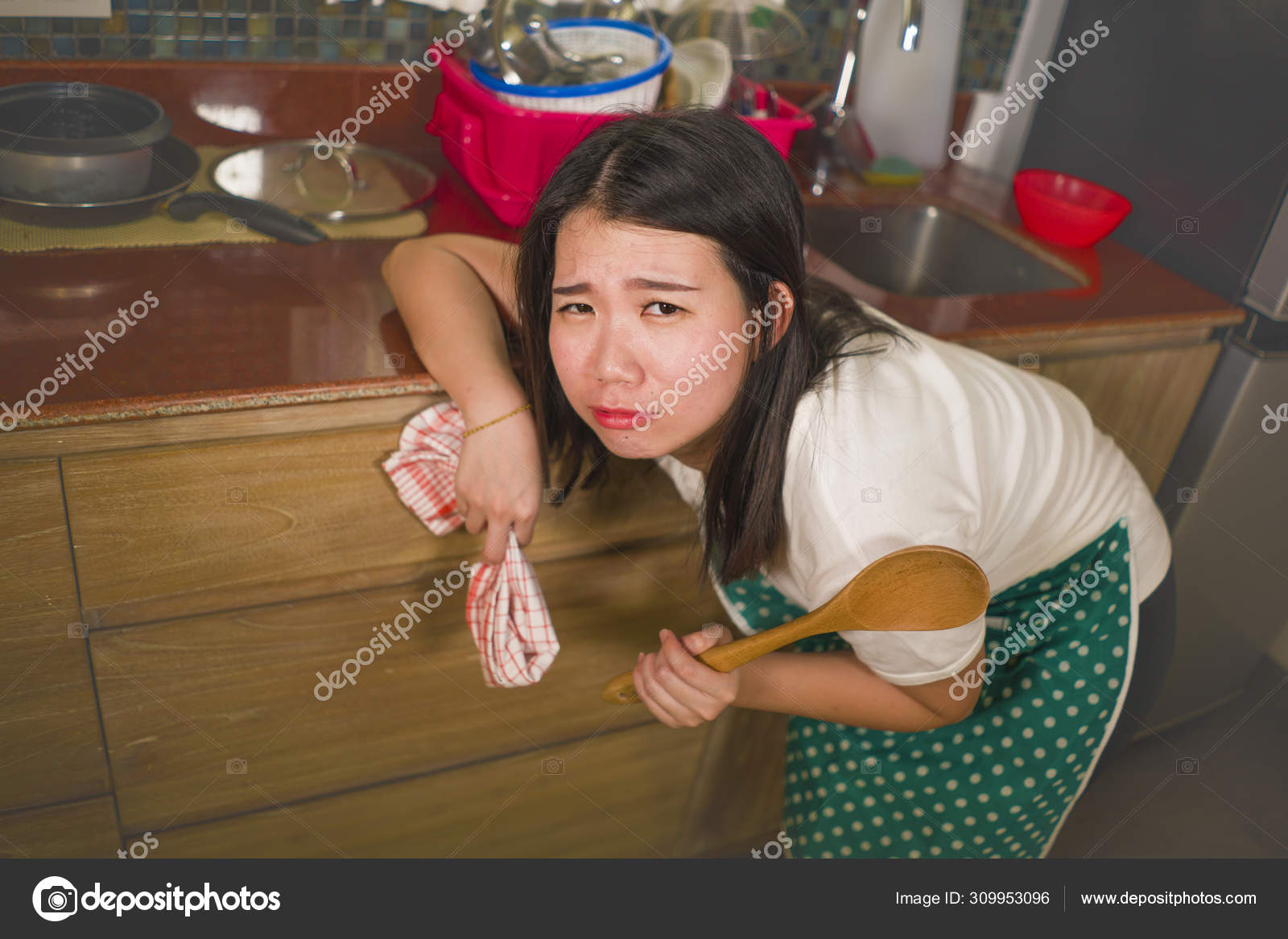 Young tired and stressed Asian Chinese woman in cook apron working ...