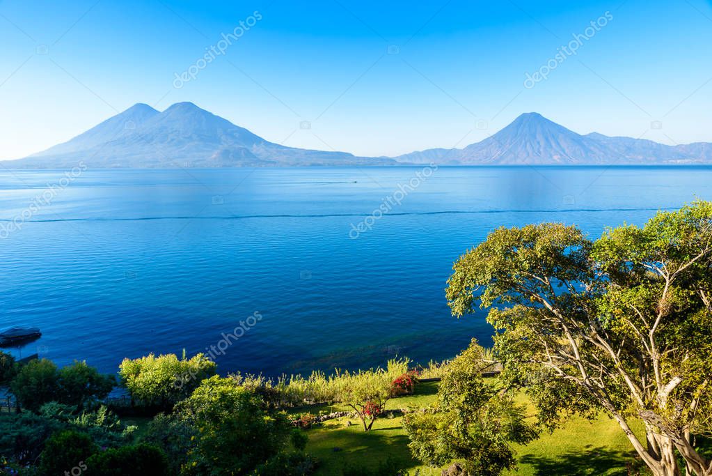 Vista desde el lago de Atitlán en la madrugada, cielos azules y aguas ...