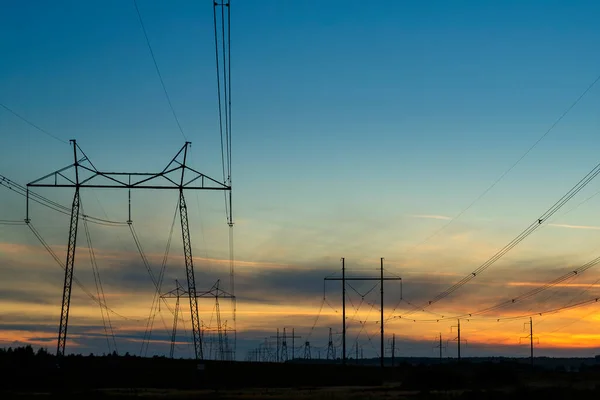High voltage power lines in the light of the setting sun. Horizontal ...