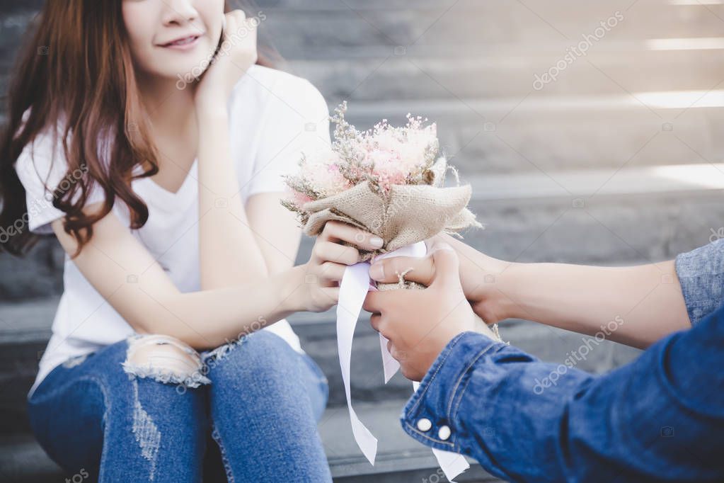 novio guapo está dando hermoso ramo de flores a su hermosa novia. Se ...