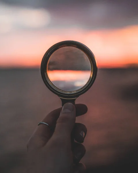 Primer plano de la mano masculina sosteniendo la lupa sobre el fondo ...