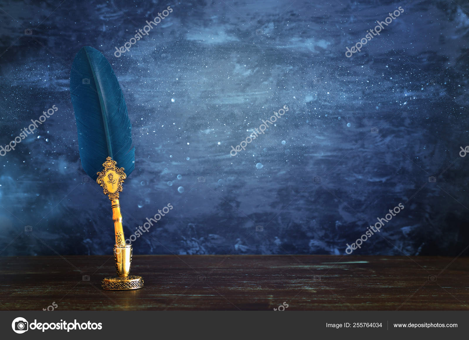 Old green feather quill ink pen with inkwell over wooden desk in Stock ...