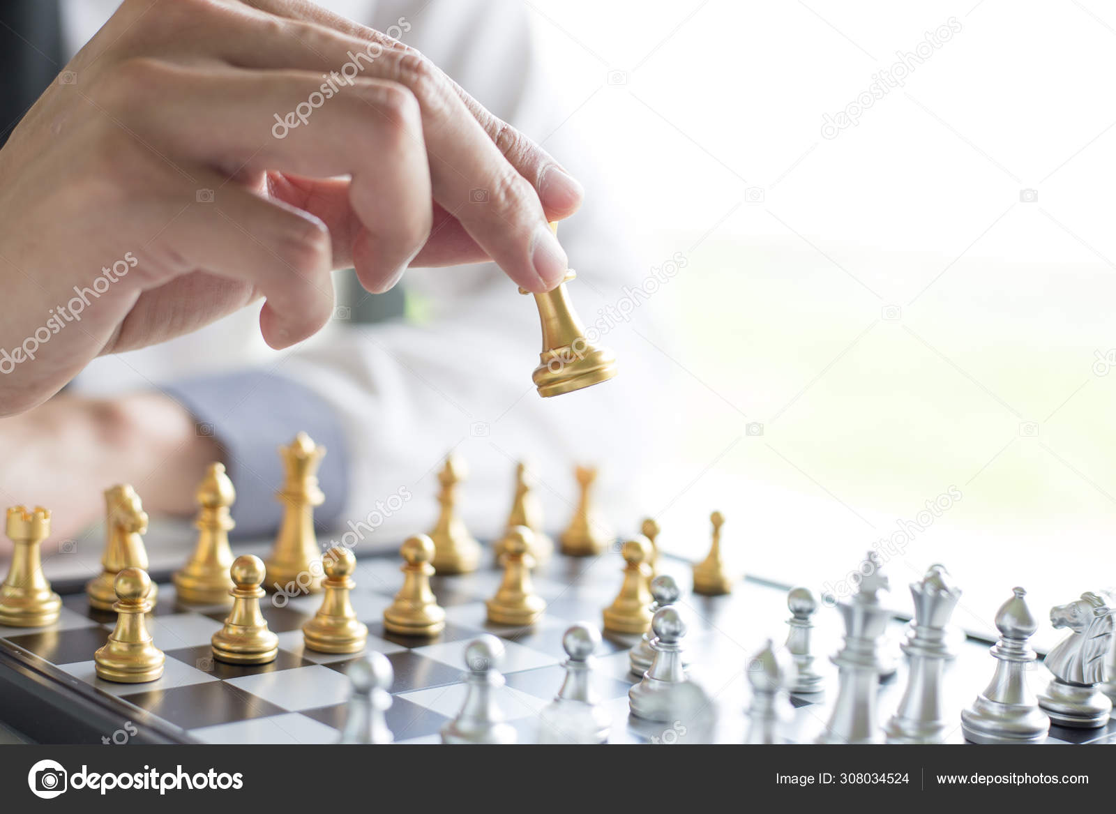 A young business man is playing chess, business strategy to be s ...