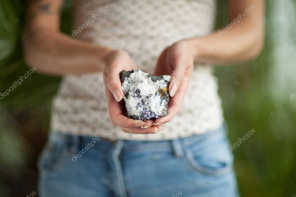 Mano de mujer sosteniendo poca roca mineral de cristal, sensual estudio ...