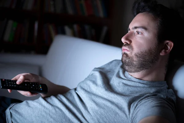Lazy man watching television at night alone - Stock Image - Everypixel