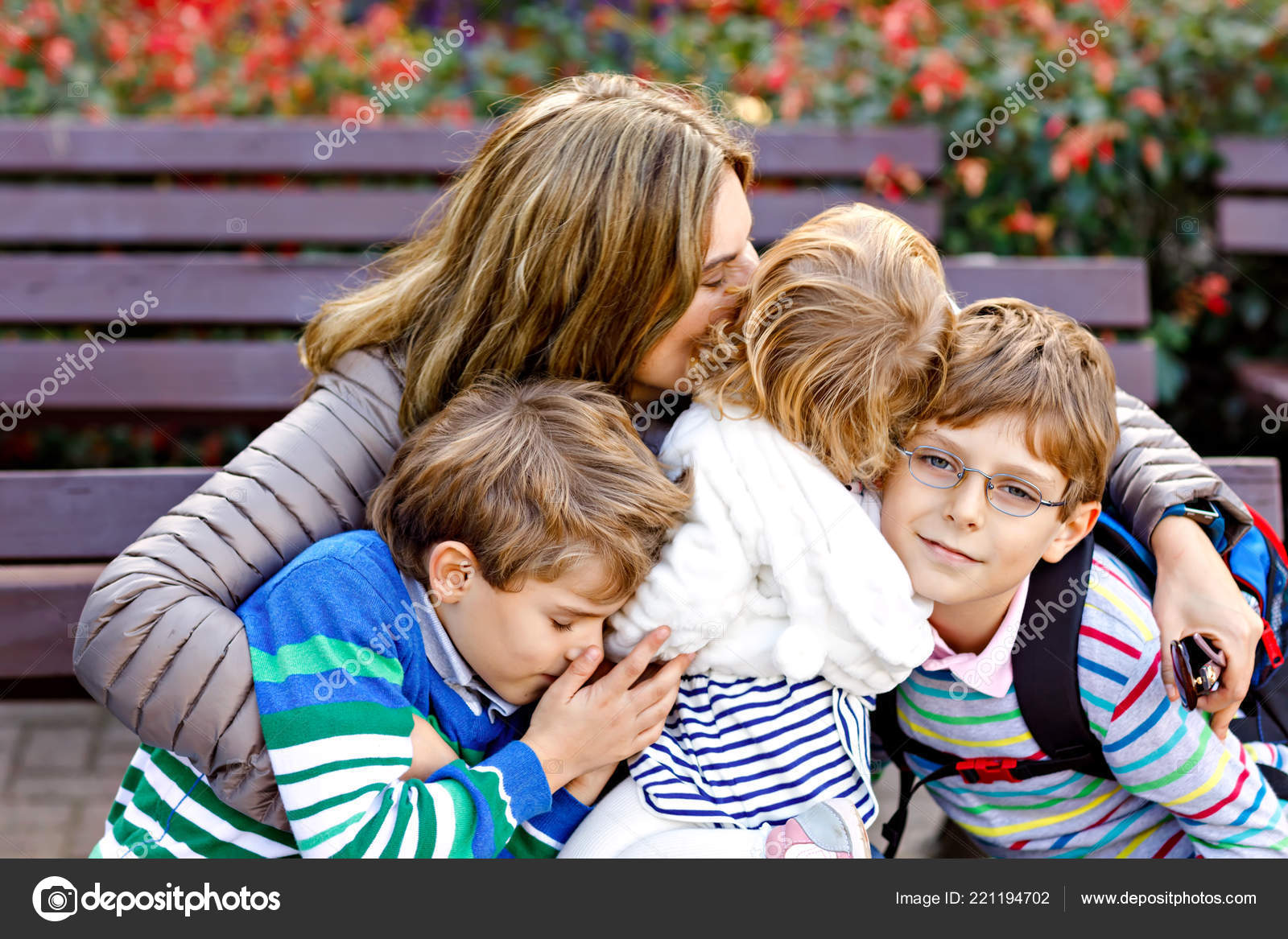 Mother and three children hugging. Happy family sitting outdoor: woman ...