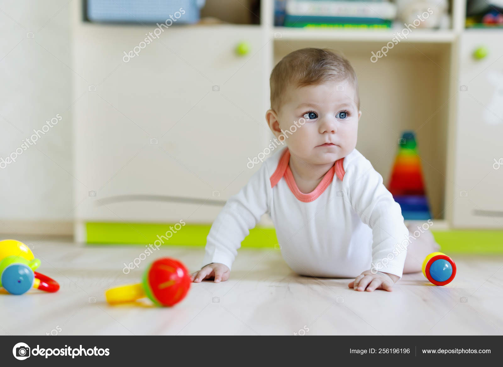 Cute happy smiling baby playing with colorful rattle toys. New born ...