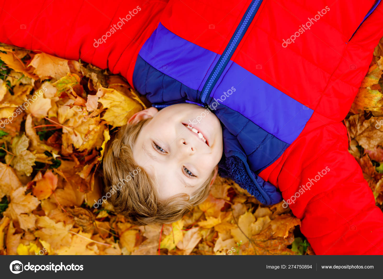 Little kid boy lying in autumn leaves in colorful fashion fall clothing ...