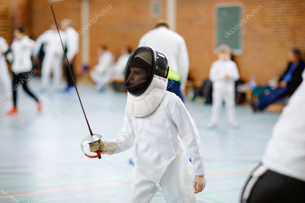 Pequeño niño esgrima en una competencia de vallas. Niño en uniforme de ...