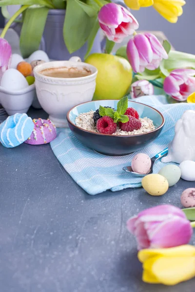 Oatmeal flakes with fresh berries and coffee. Spring tulips. Sweet ...