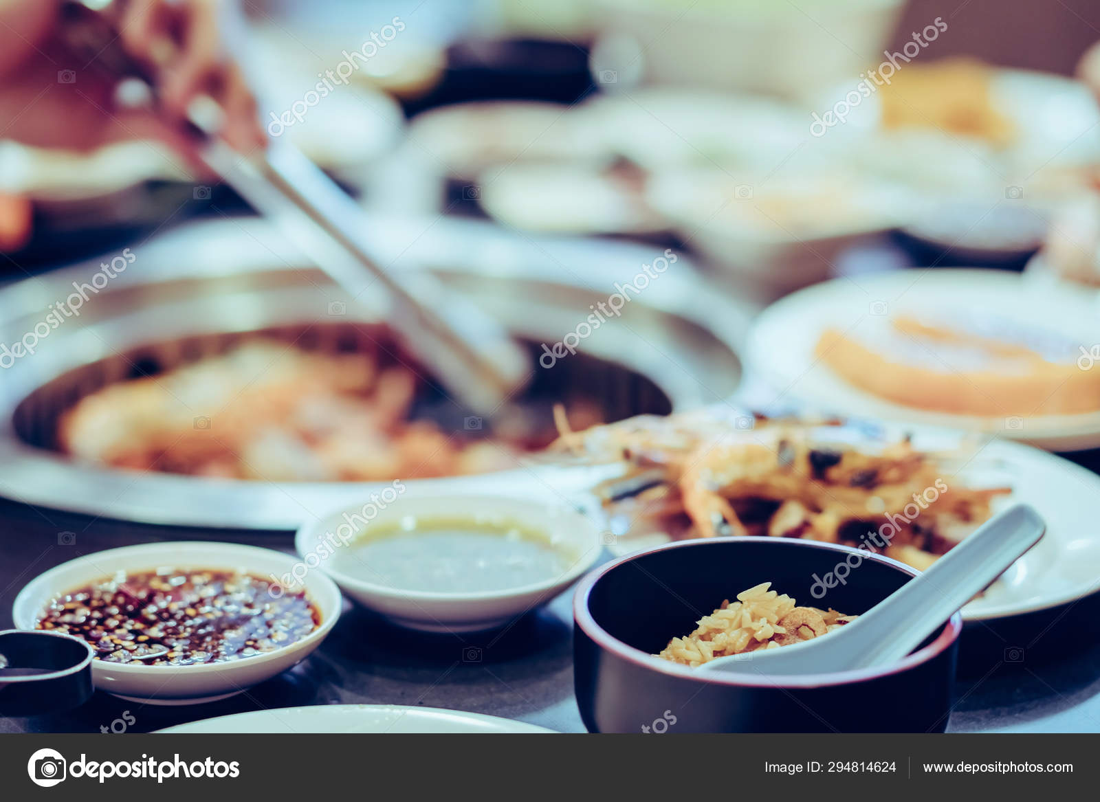 People grilling meat on a smokeless barbecue grill in a restaurant ...