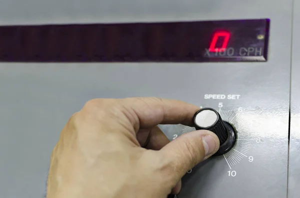 Hand on manual speed regulator button on industrial offset printing ...