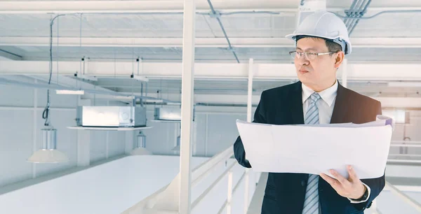 Long distance shot of Asian executive engineer in white helmet using ...