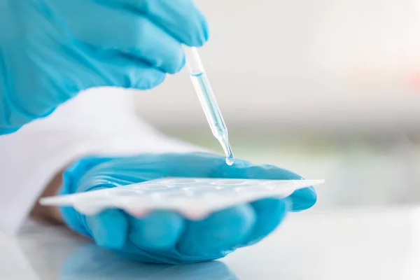 Scientist dropping liquid to sample tray - Stock Image - Everypixel