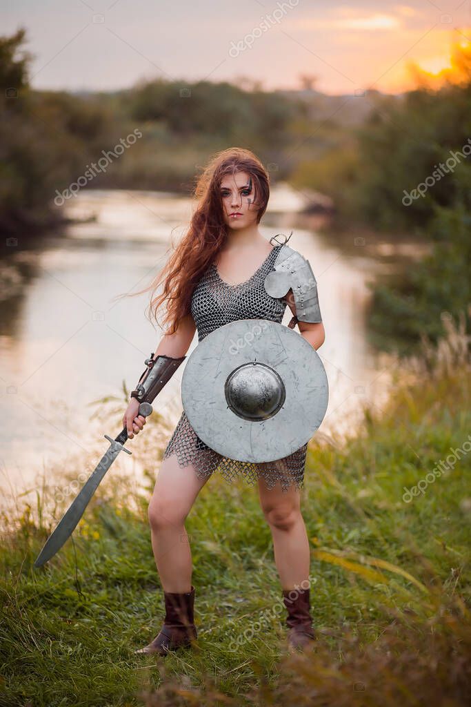 Mujer guerrera de fantasía medieval con pintura de guerra en la cara, con una armadura de malla ...
