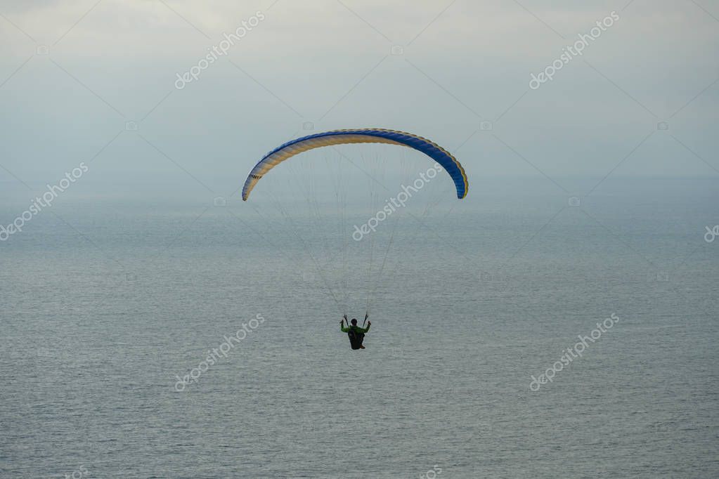 Hombre haciendo deporte (Para-planeador). Hombre parapente en el cielo ...