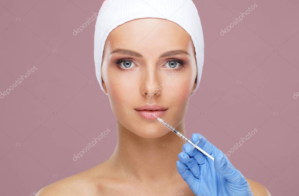Doctor inyectando en una cara hermosa de una mujer joven. Cirugía ...