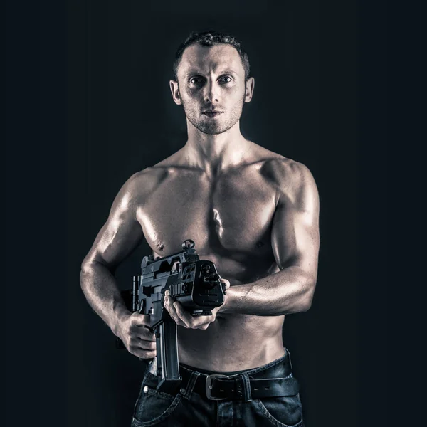 Confident young man shirtless portrait training with dumb-bell against ...