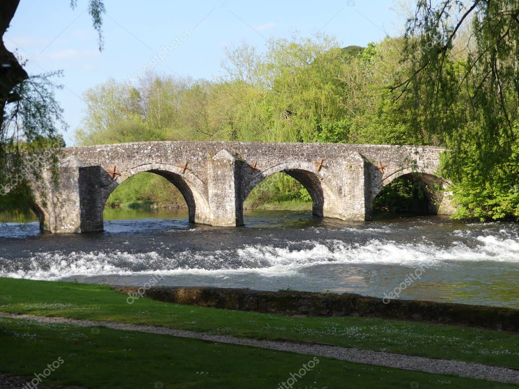 Un puente medieval de piedra que cruza el río Exe en la aldea de ...