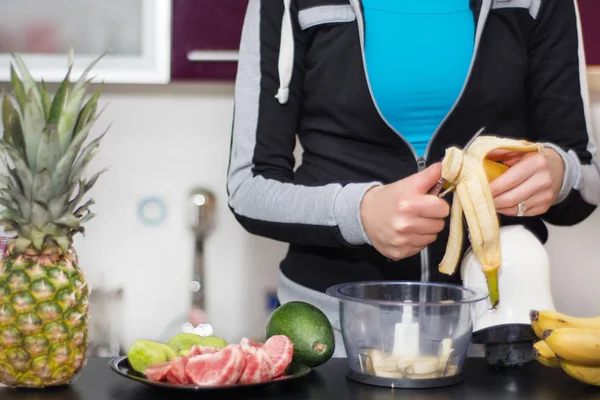 Woman make smoothie with banana in kitchen. Ingredients for shake on ...