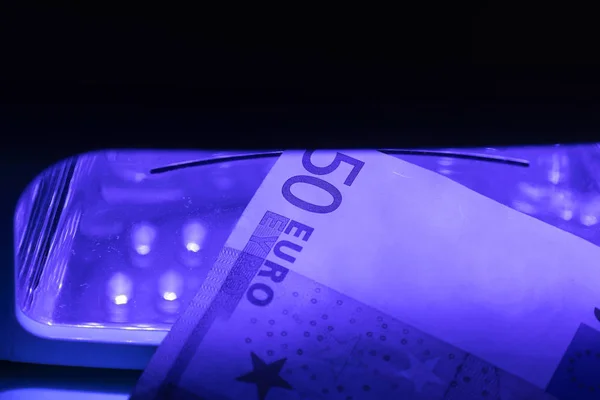 100 Euro banknote. Lying in the ultraviolet to verify the authenticity ...
