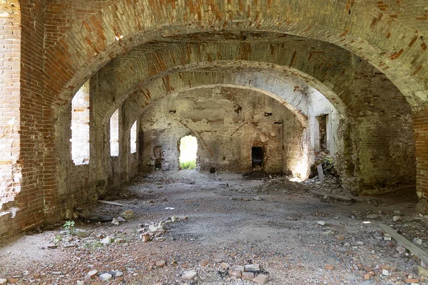 Old dilapidated red brick building. The room inside with vaults of ...