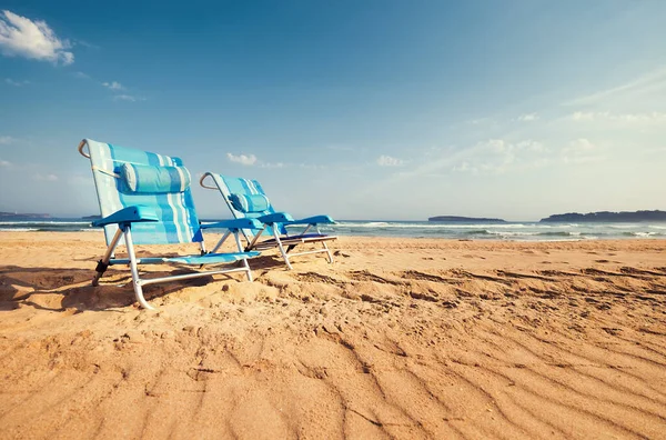 Young couple siting in cozy chears on the wild sea beach — Stock Photo ...