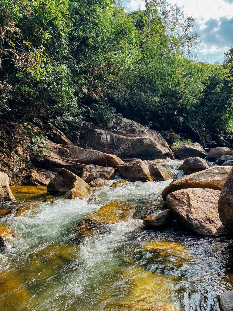 Un pequeño río de montaña fluye entre grandes piedras en áreas ...