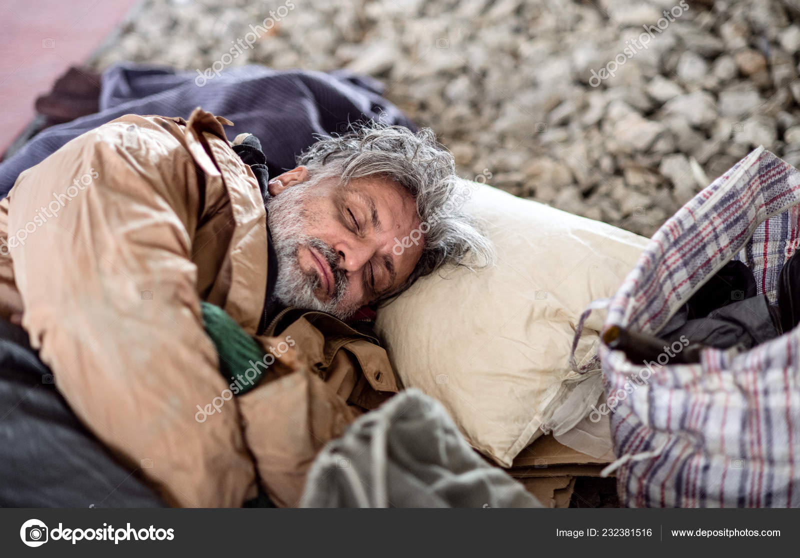 Homeless beggar man lying on the ground outdoors in city, sleeping ...