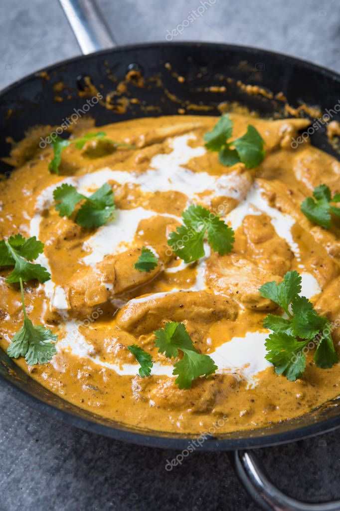 Curry de pollo indio anaranjado con crema y hojas frescas de coriadner ...